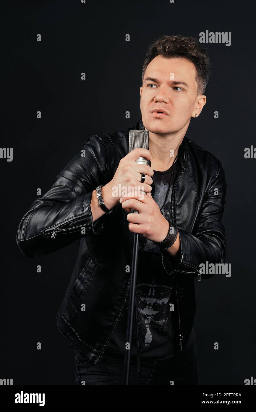 Low key portrait of man singing and holding microphone Stock Photo - Alamy