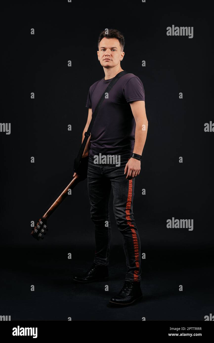 Full length portrait in low key of musician standing with guitar Stock ...