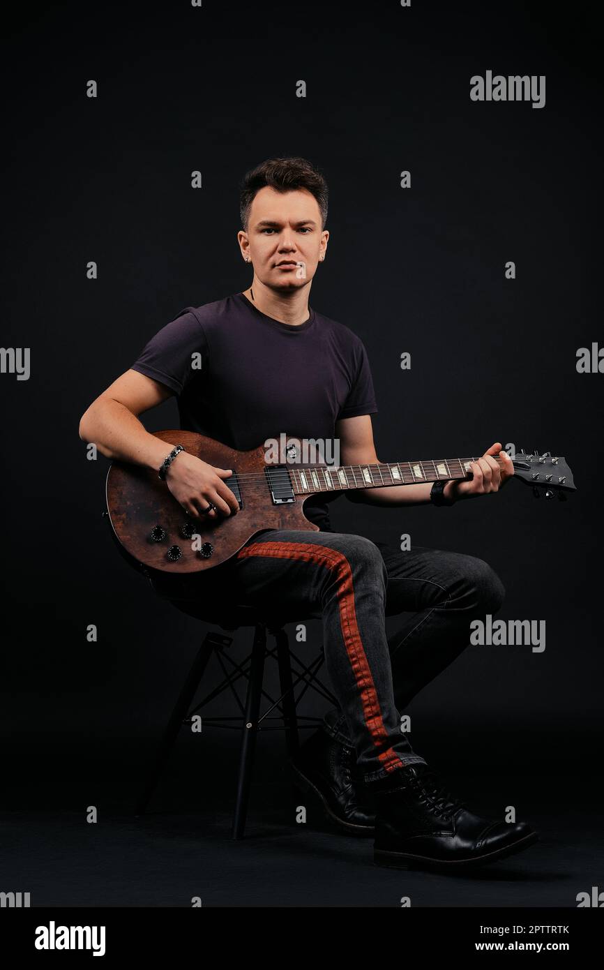 Low key portrait of man singing and playing electro guitar Stock Photo - Alamy
