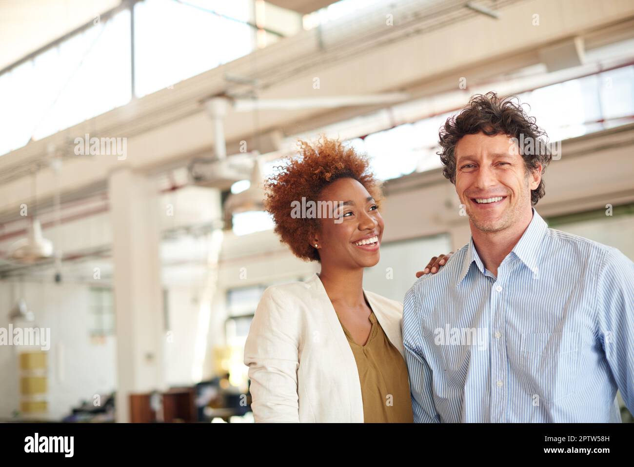 Happiness is the key to success. Portrait of two coworkers standing in ...
