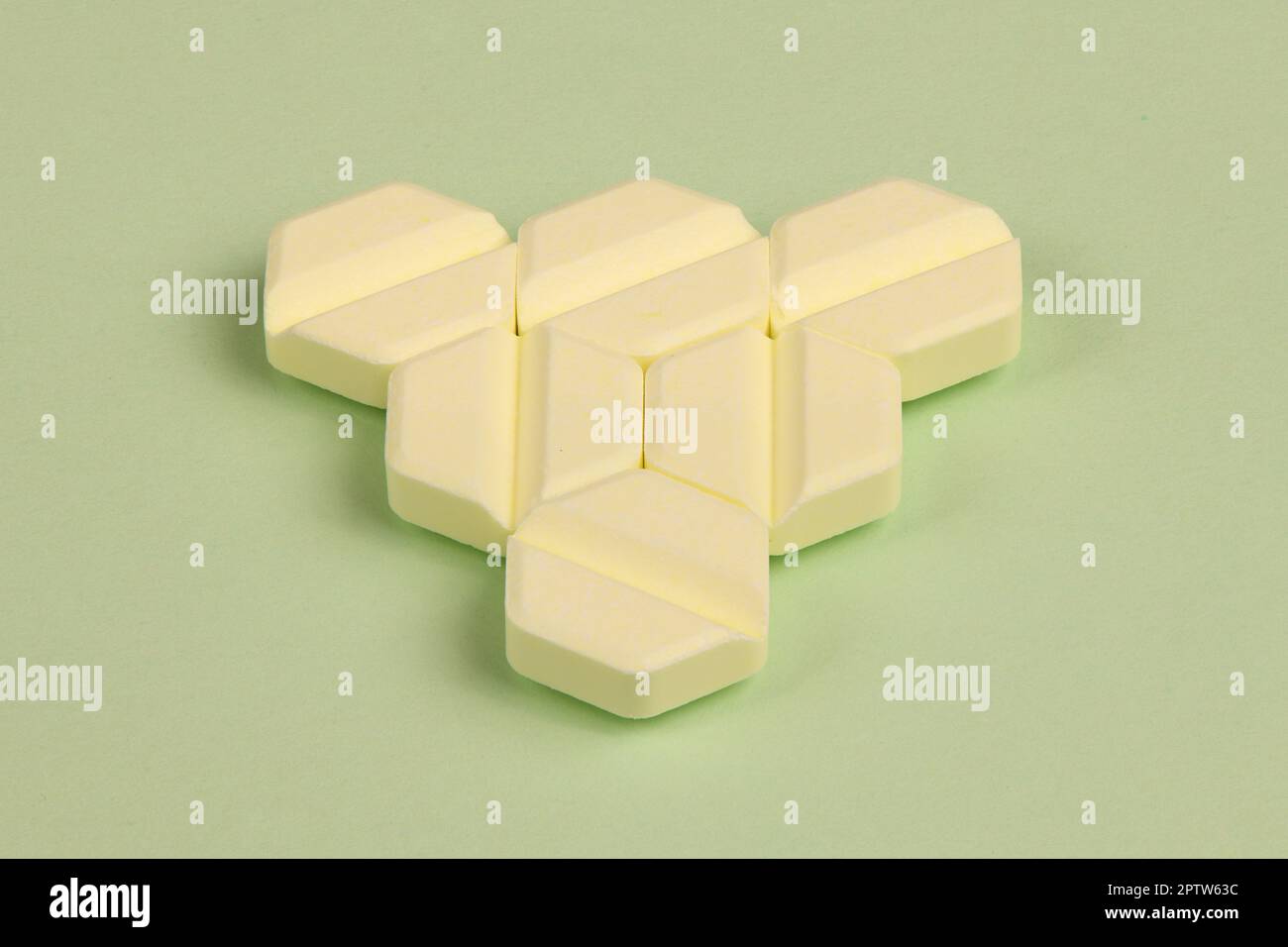 Hexagonal pills on light green background. Extreme closeup. High ...