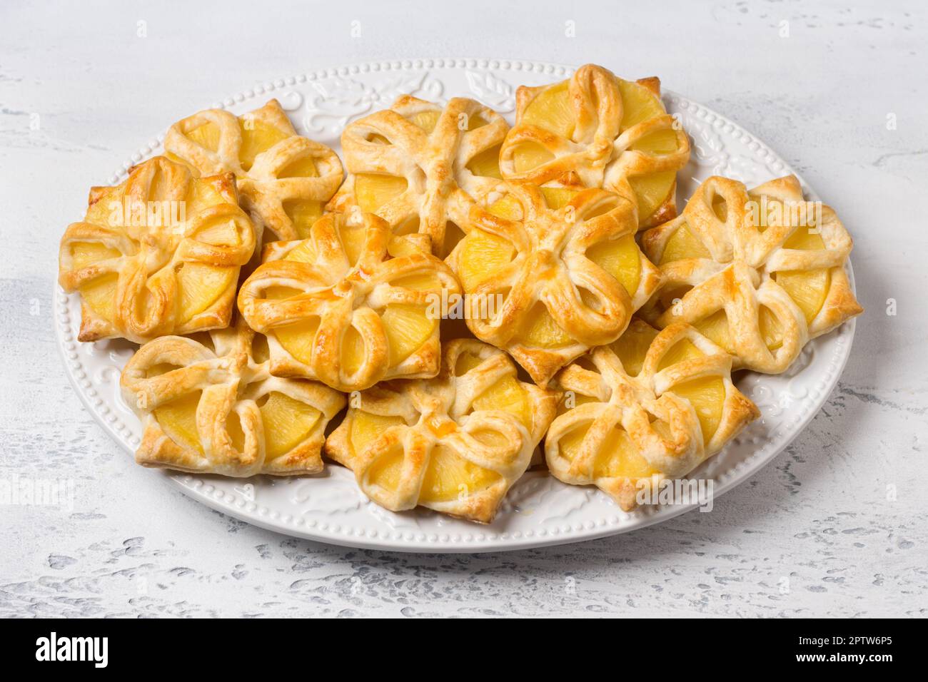 Baked pineapples in puff pastry on a light gray-blue background, top ...