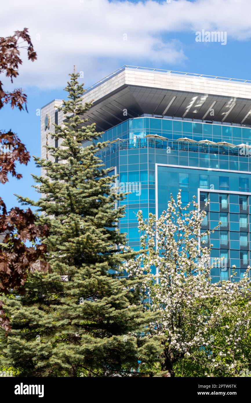 Modern, blue glass hotel building facade in spring greenery on Freedom ...