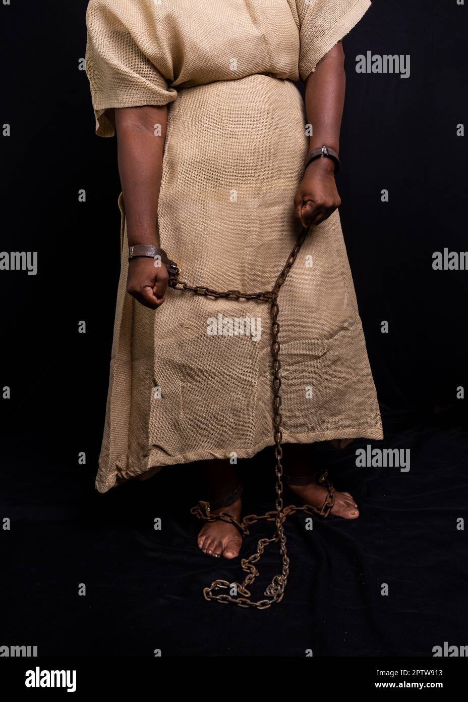 Black woman, standing, chained and with an iron mask on her face ...