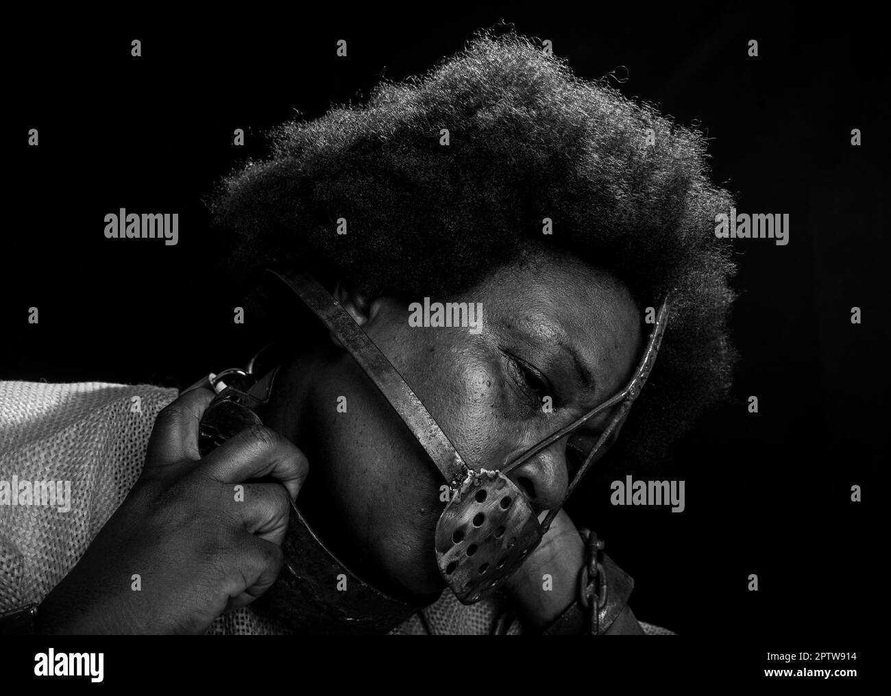 Face portrait of a black woman imprisoned with an iron mask on her face ...