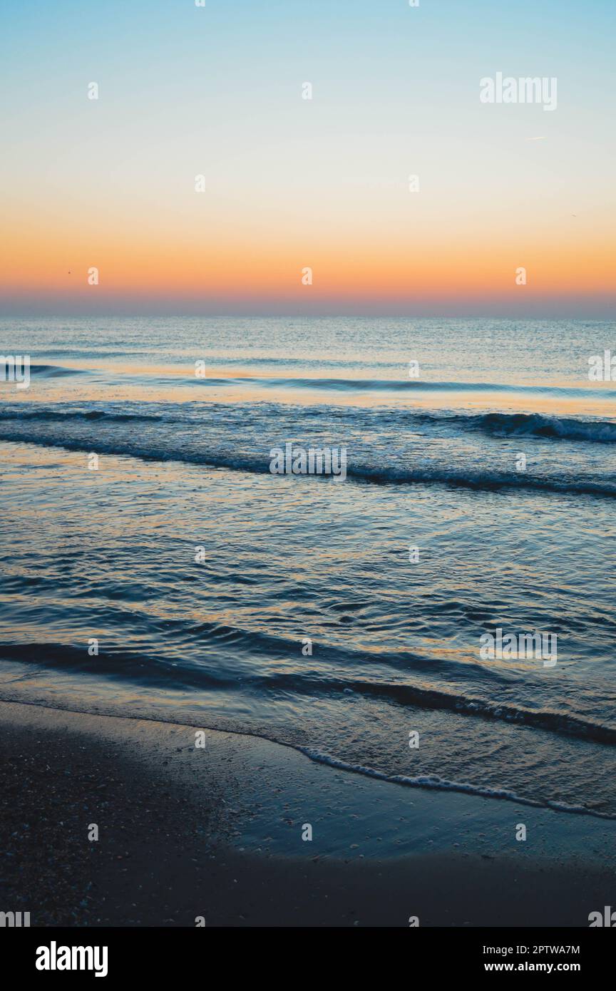 Beautiful summer landscape, sunset at the beach, sparkly sand and waves ...