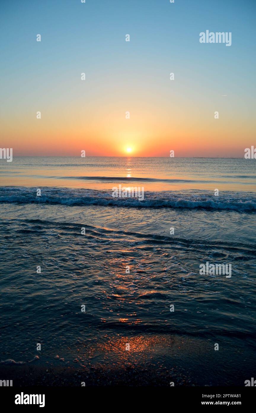 Beautiful summer landscape, sunset at the beach, sparkly sand and waves ...