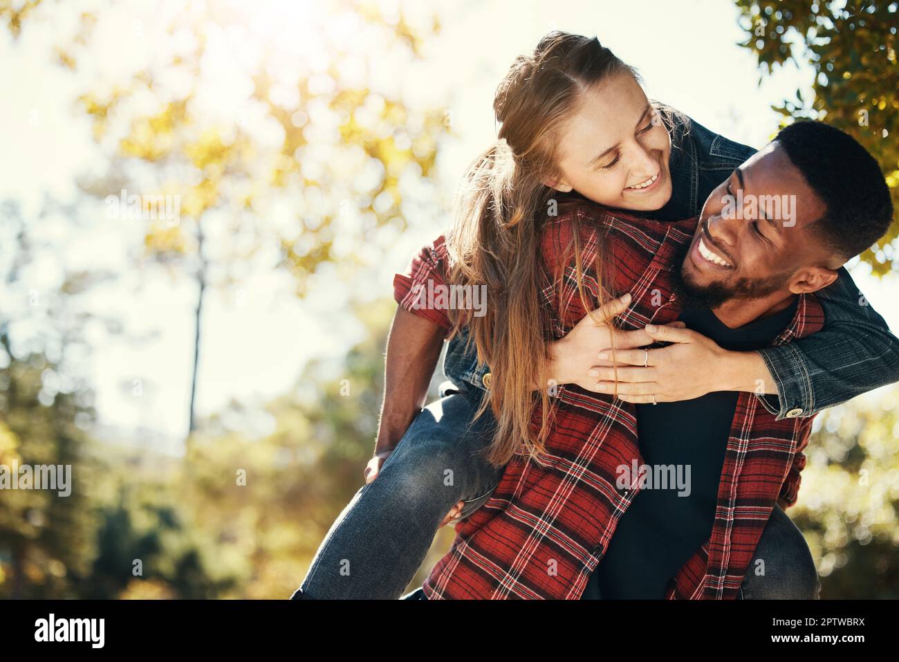 Love, couple and piggy back in nature on vacation, holiday or date outdoors. Romance, diversity ...