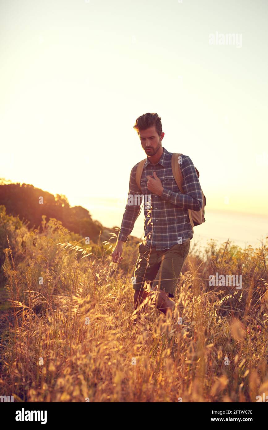 Making his way through nature. a handsome young man enjoying a hike ...