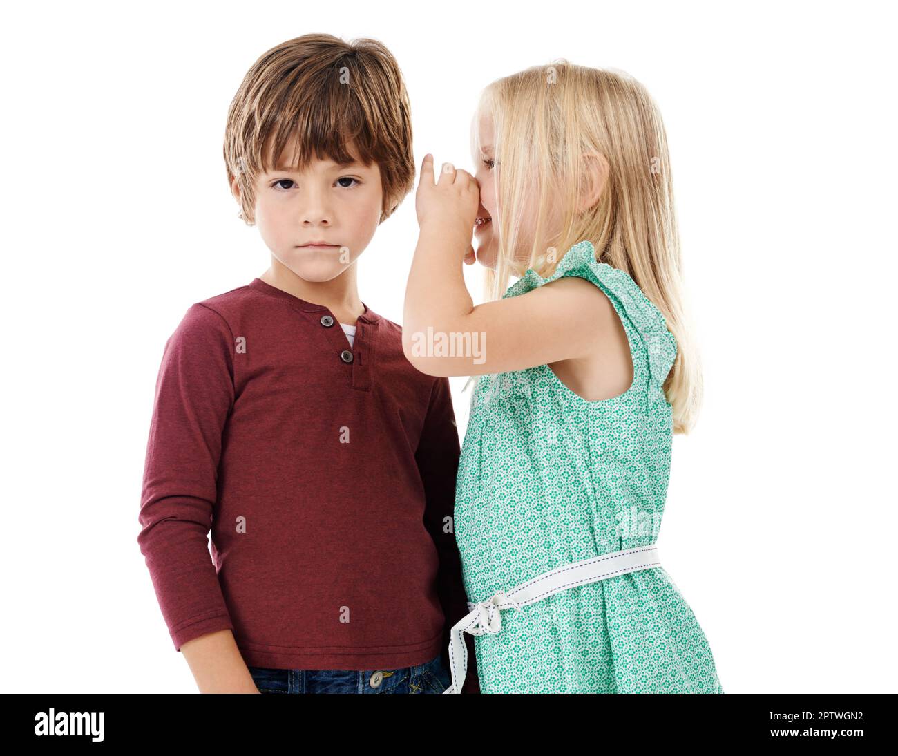 Dont tell anybody...Studio shot of a cute little girl whispering ...