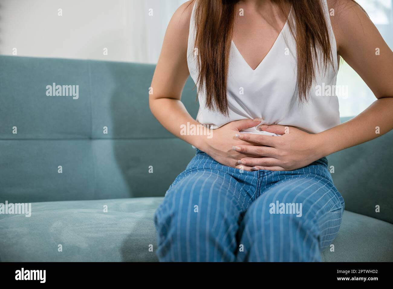 Asian young woman unhappy hands holding on stomach suffering from ...