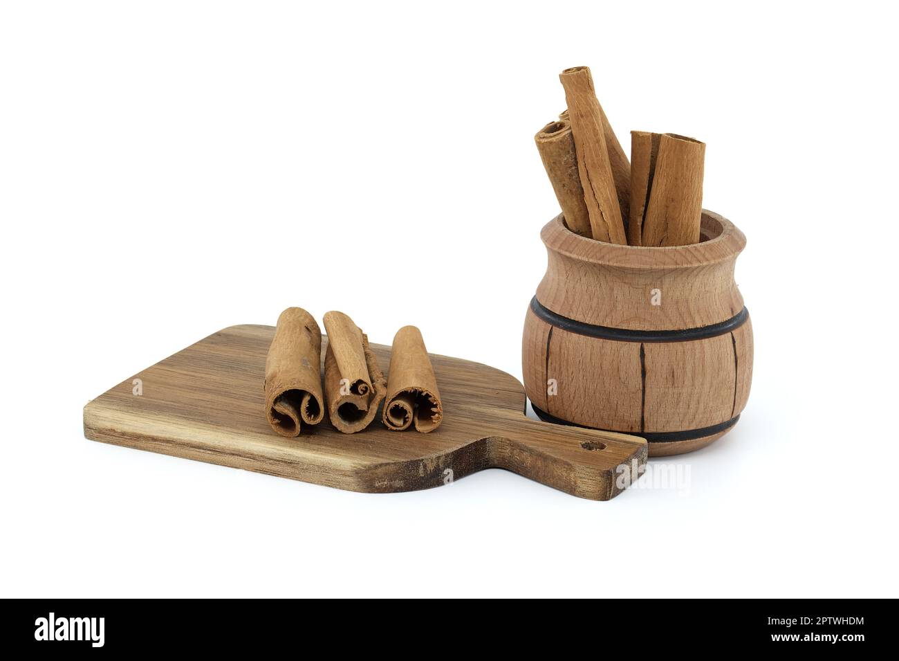 Cinnamon sticks in a small wooden pot isolated on white background ...