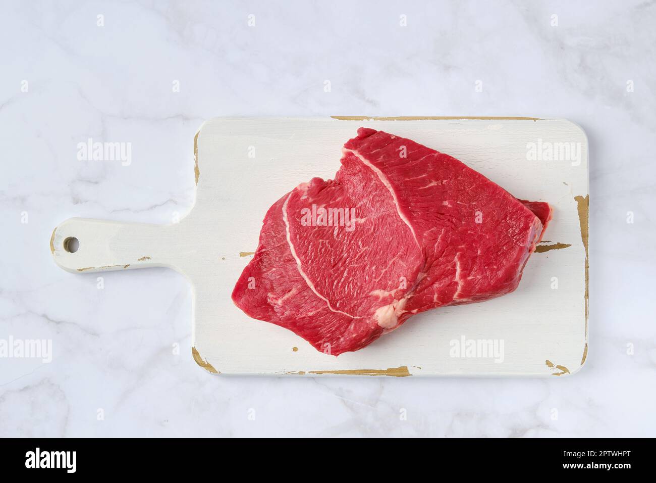 Top view of raw top side beef steak on marble background Stock Photo ...