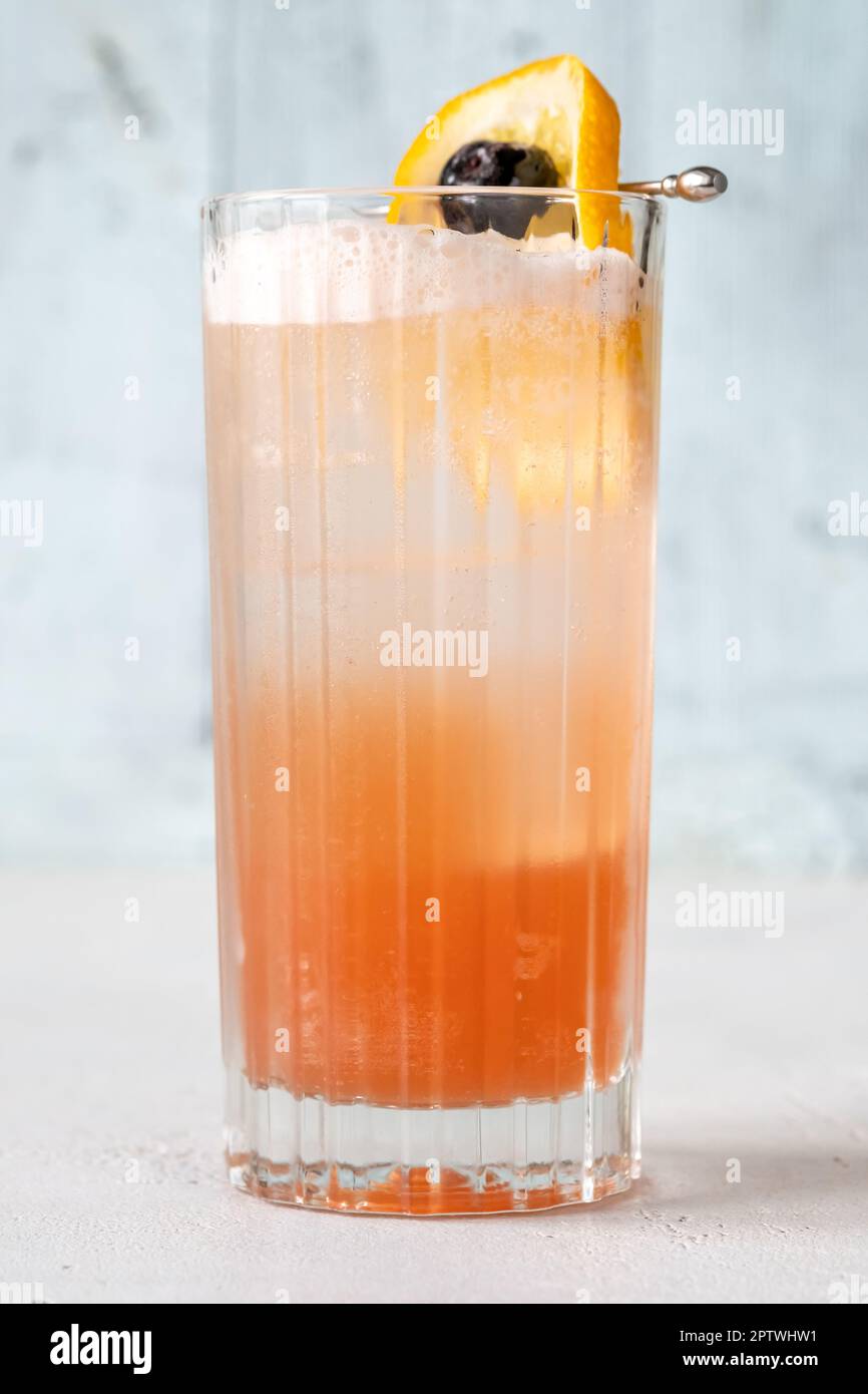 Singapore Sling cocktail garnished with orange wheel and cherry Stock ...
