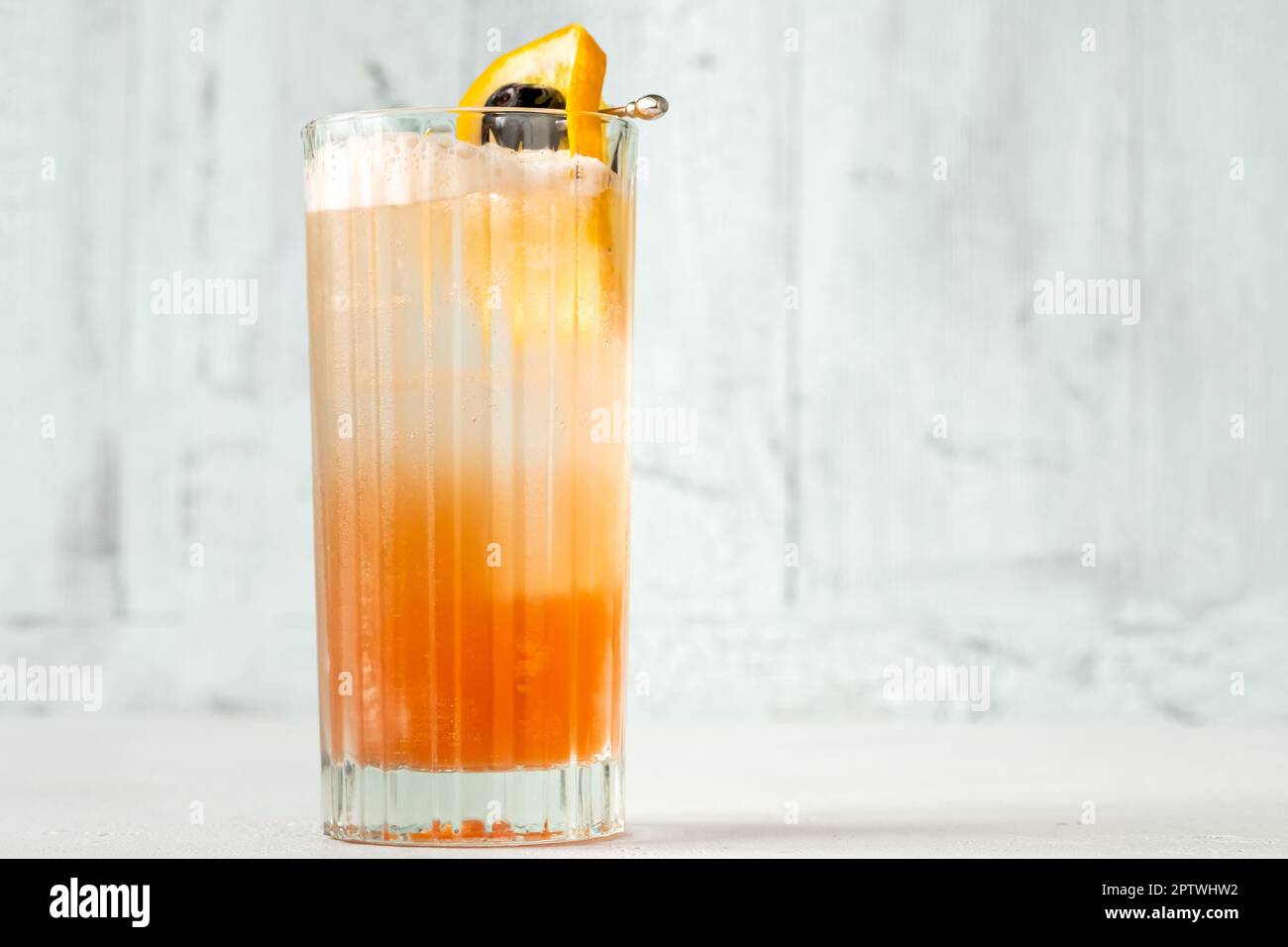 Singapore Sling cocktail garnished with orange wheel and cherry Stock ...