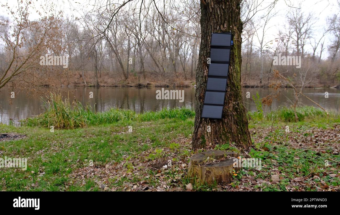 portable solar panel on thr tree charging smartphone by mutlipurpose ...