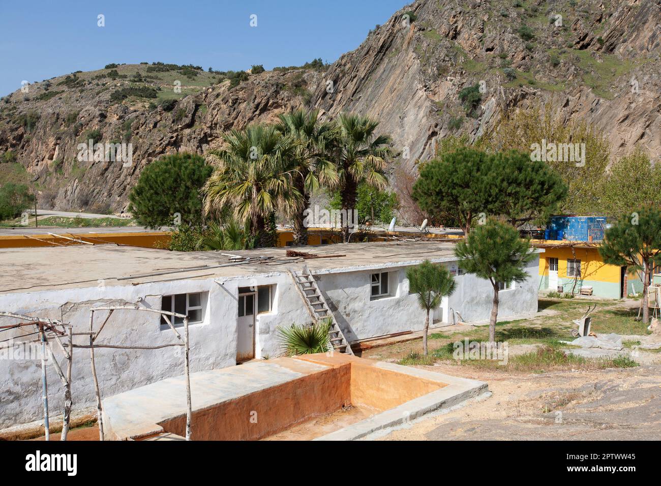 a poor house in a village in the middle of mountains between palm trees ...