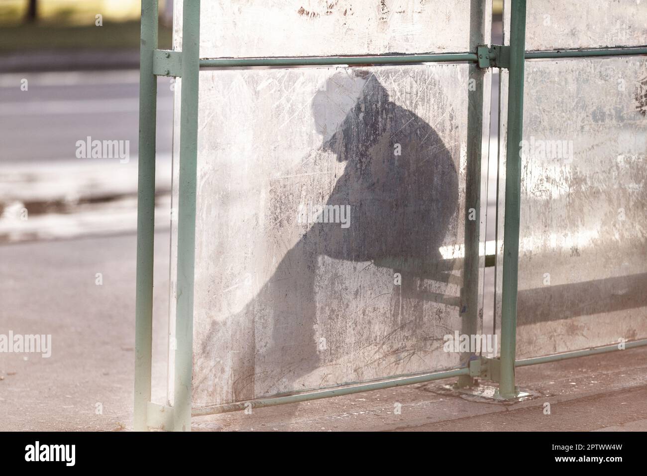 silhouette behind the glass of a lonely man sitting at a bus stop Stock ...