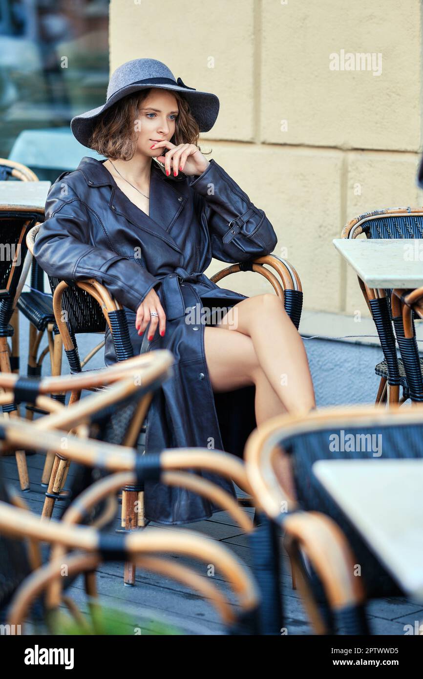 Pretty actress sitting at coffee shop table looking pensive and focused ...