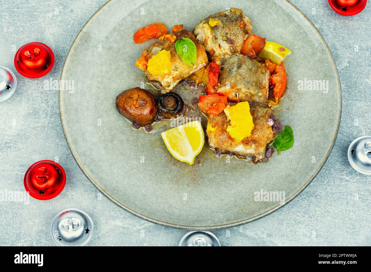 Fish hake cooked with mushrooms, orange and tomatoes. Christmas food ...