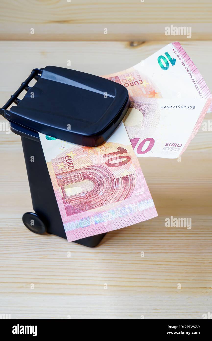 Euro banknote in a garbage can as a symbol for garbage fees, waste of ...