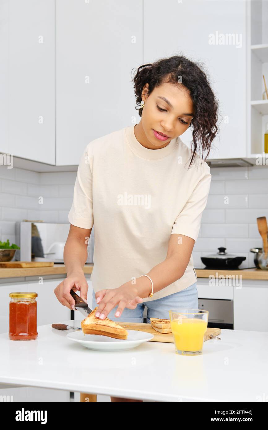 Pretty african woman putting sweet toasted bread on a plate Stock Photo ...