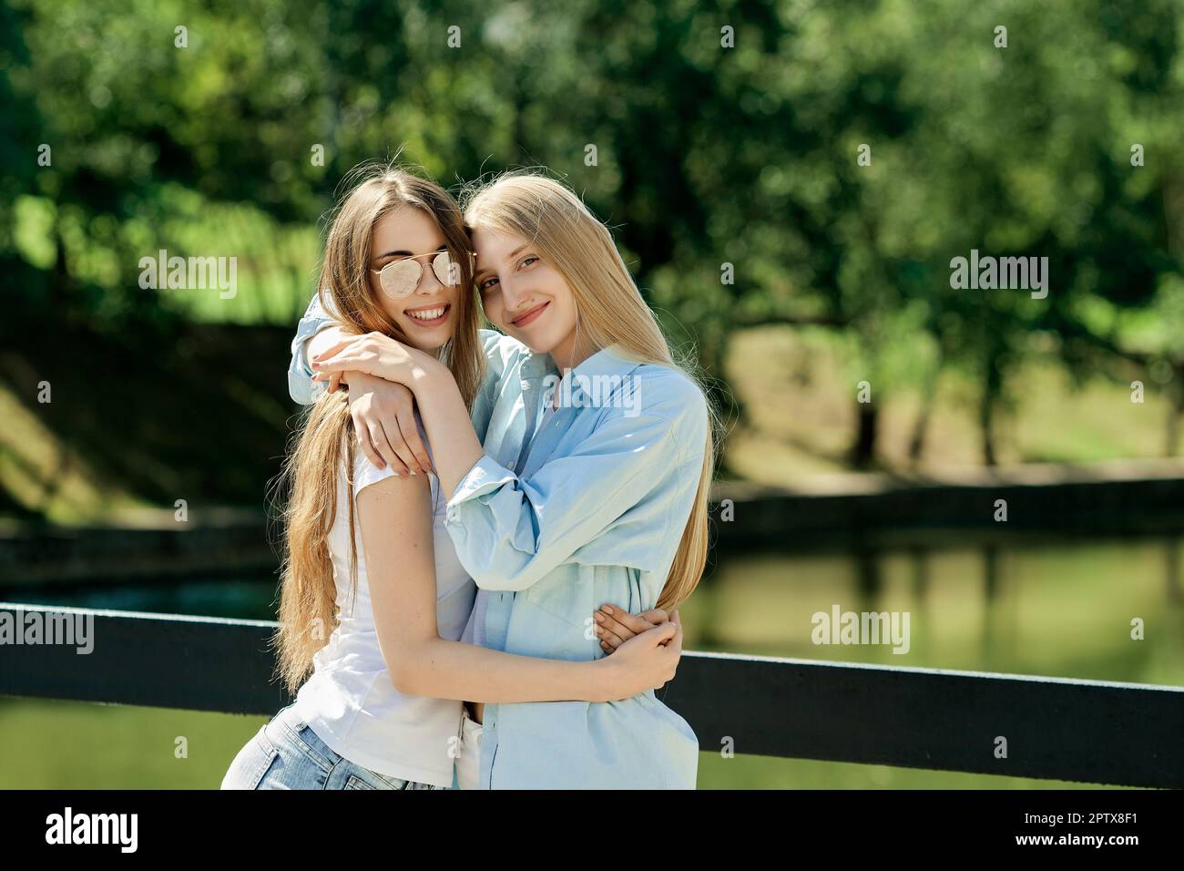 Two beautiful young women hugging each other Stock Photo - Alamy