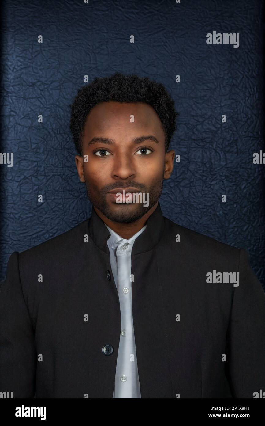 twenty year old man headshot suit style on black background vertical ...