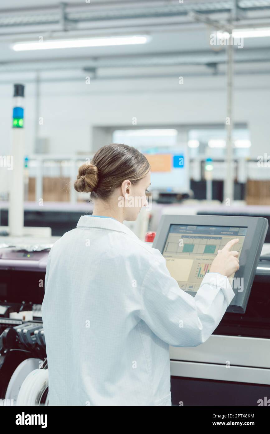 Woman on control compute of assembly line in electronics factory Stock ...