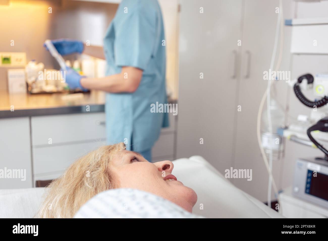 Patient woman in hospital watching nurses preparing for surgery Stock ...