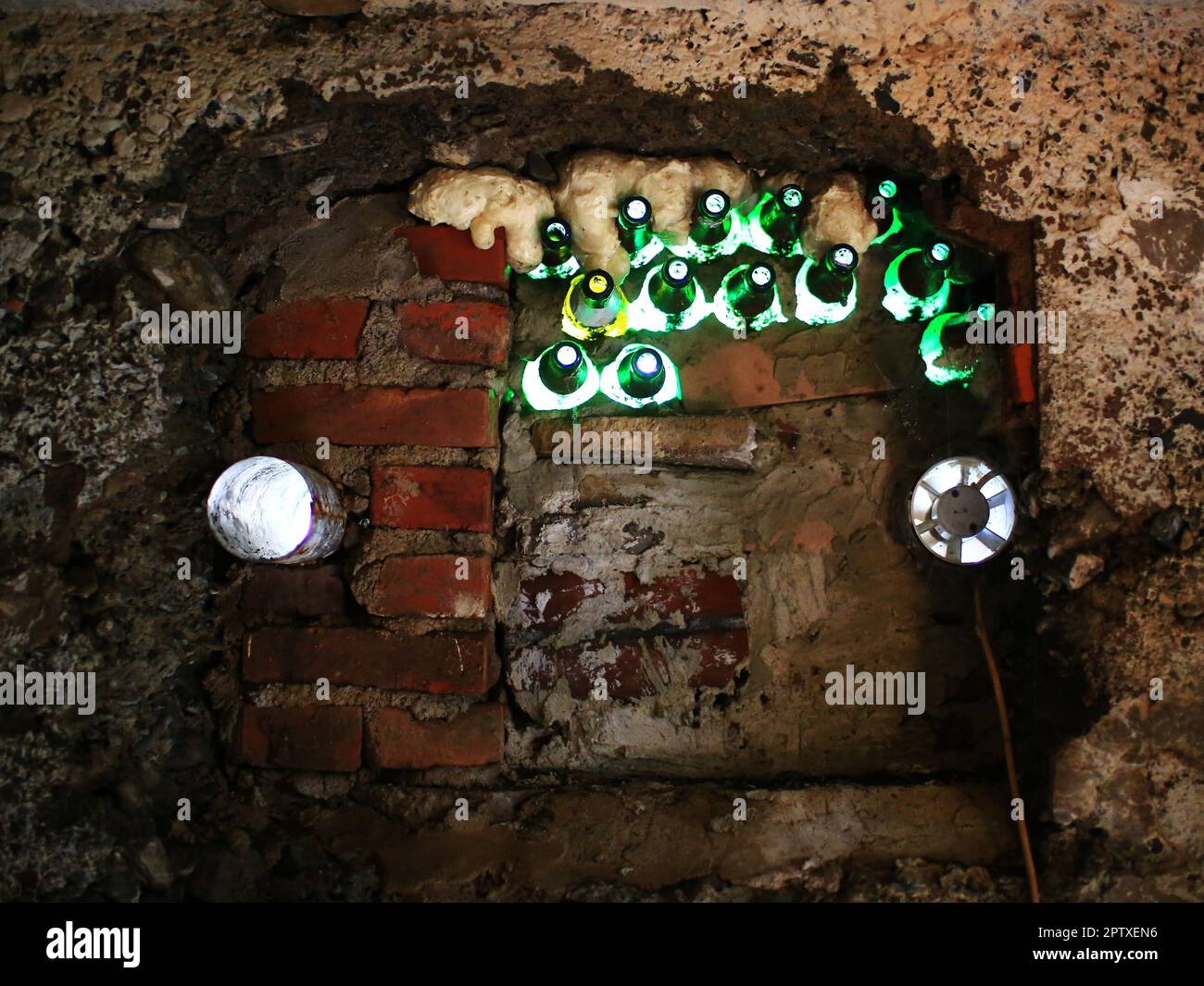 Makeshift window made of bricks, bottles and pipes for ventilation ...