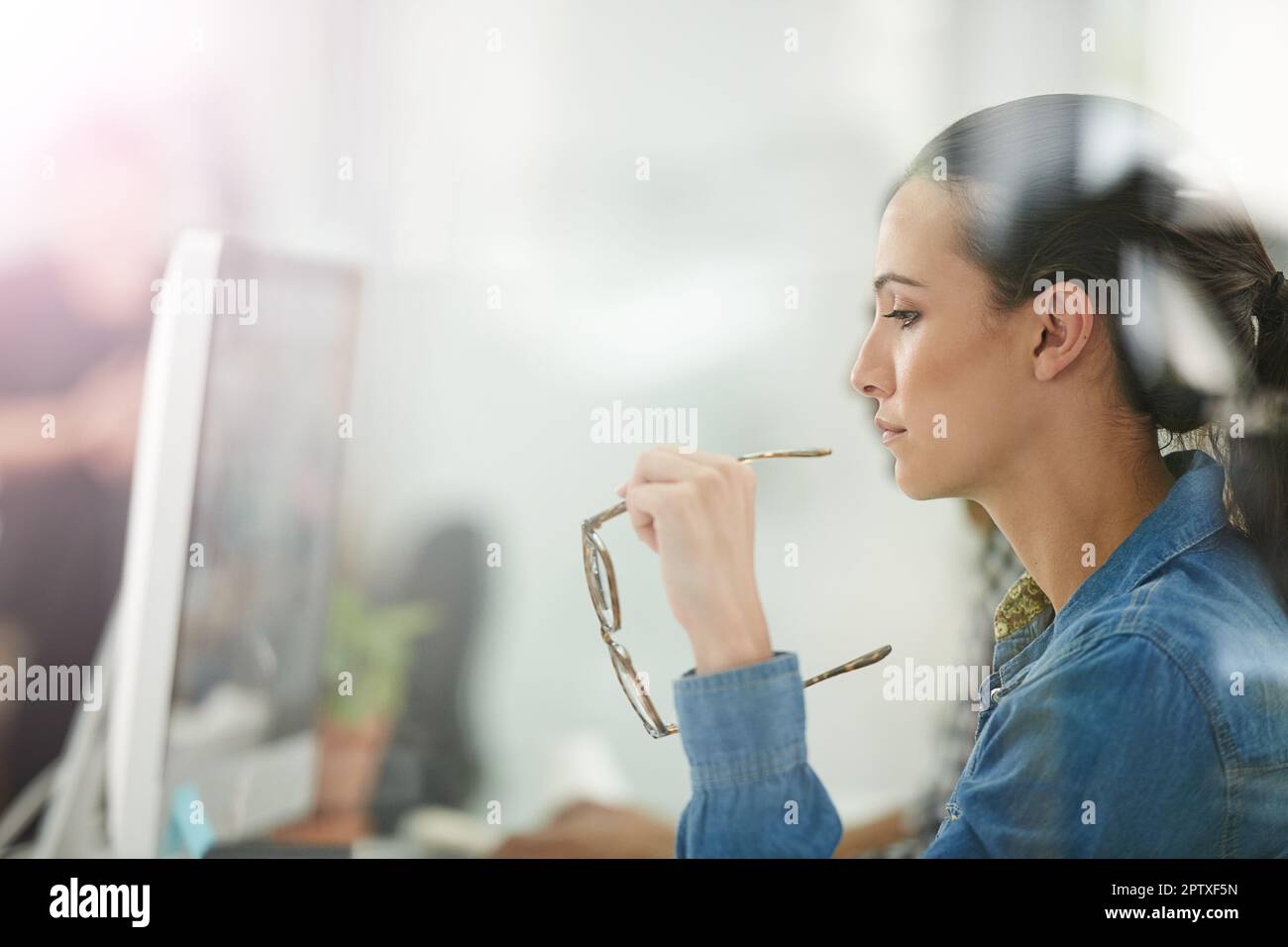Putting a lot of thought into her work. a young businesswoman at her desk Stock Photo - Alamy