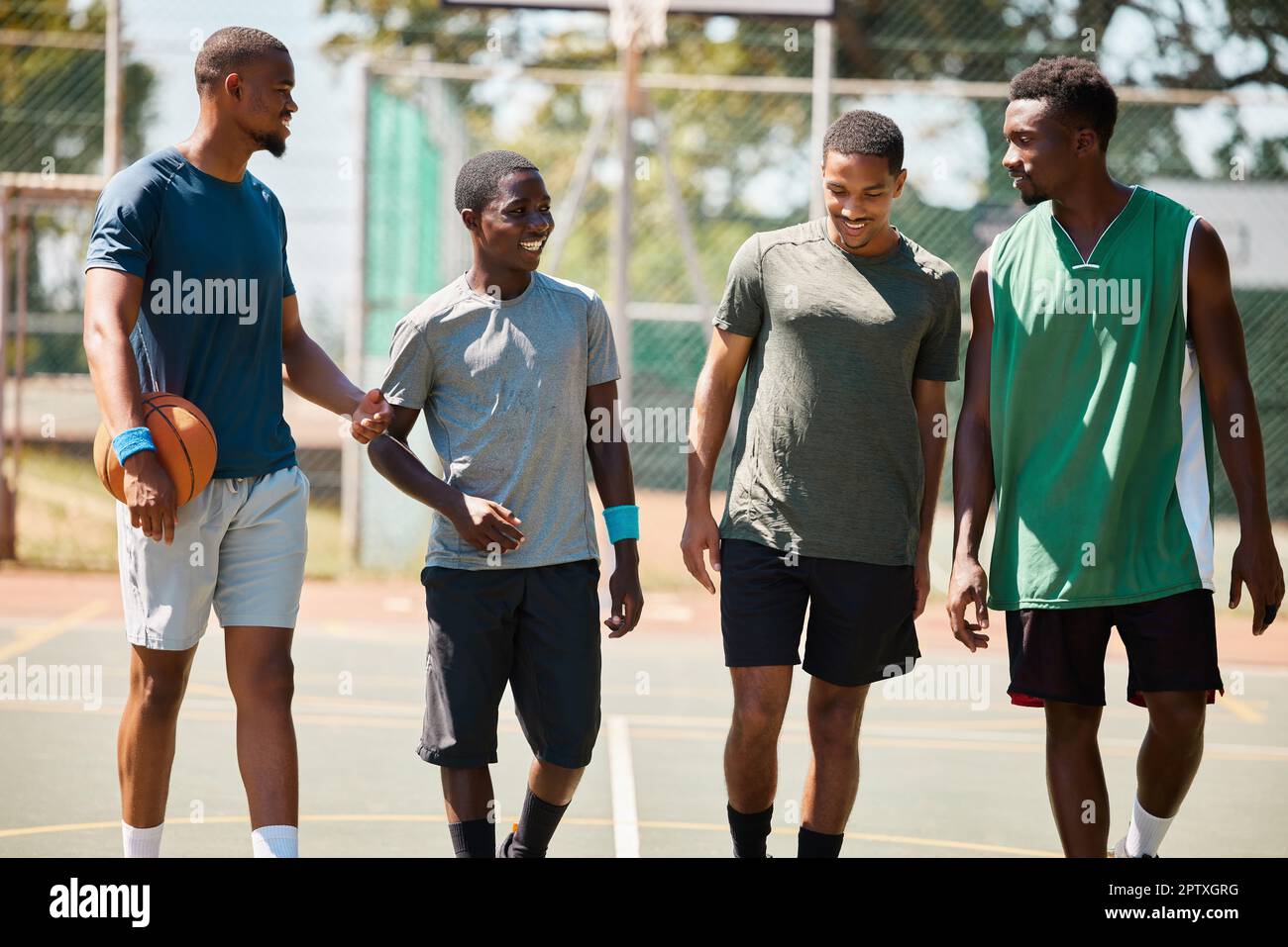 Team walking, basketball and conversation on sports court for fitness ...