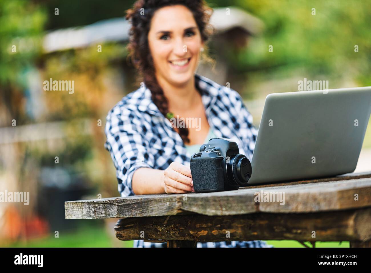 Human photographer works on her shoot in the countryside, outdoors. She ...
