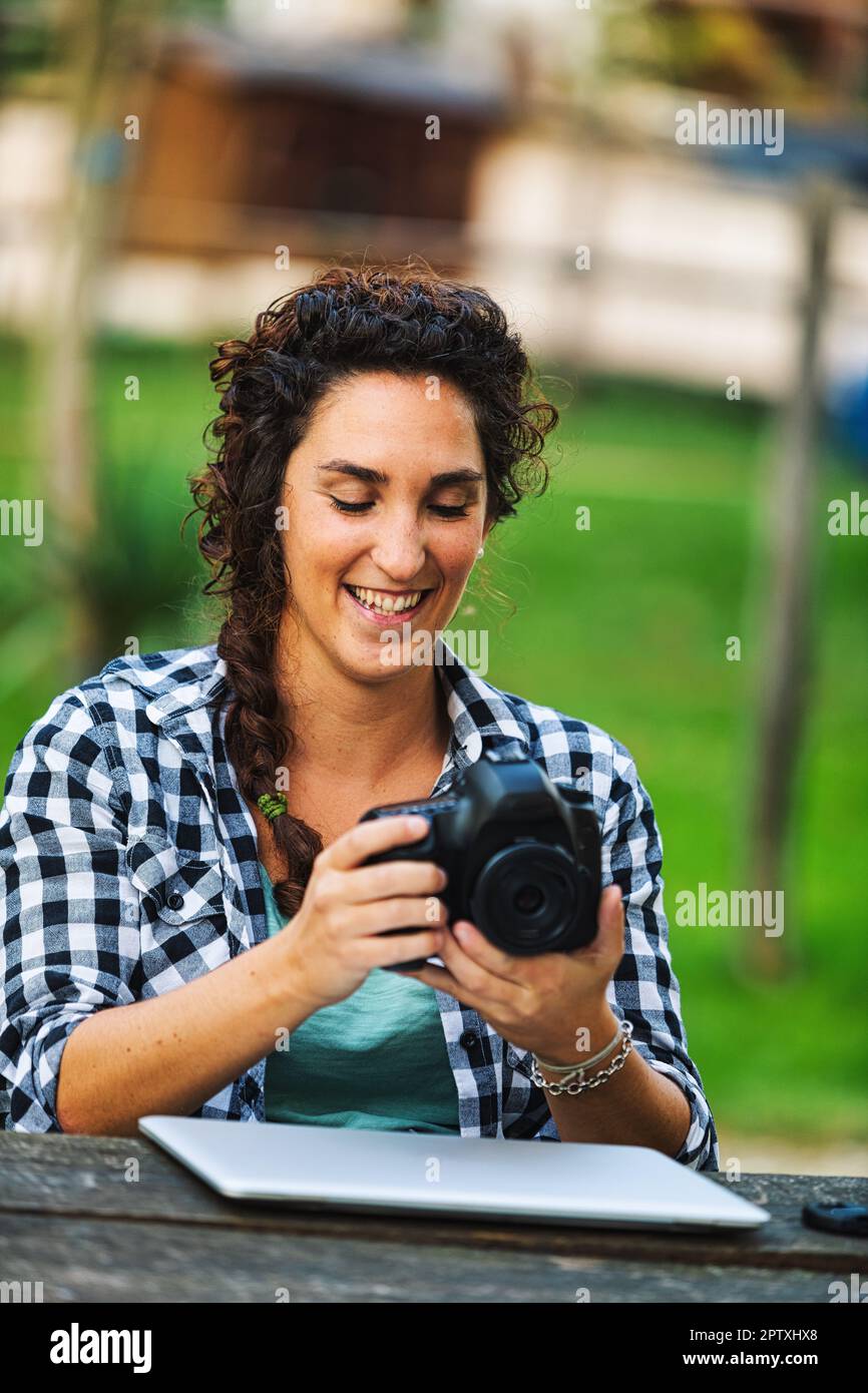 Human photographer works on her shoot in the countryside, outdoors. She ...