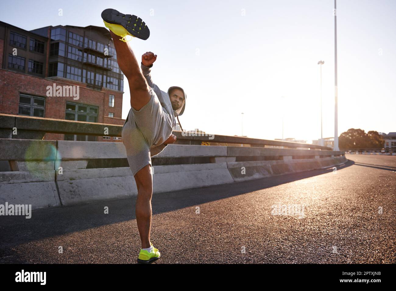 High kick of excellence. A young fighter in sportswear giving a high ...