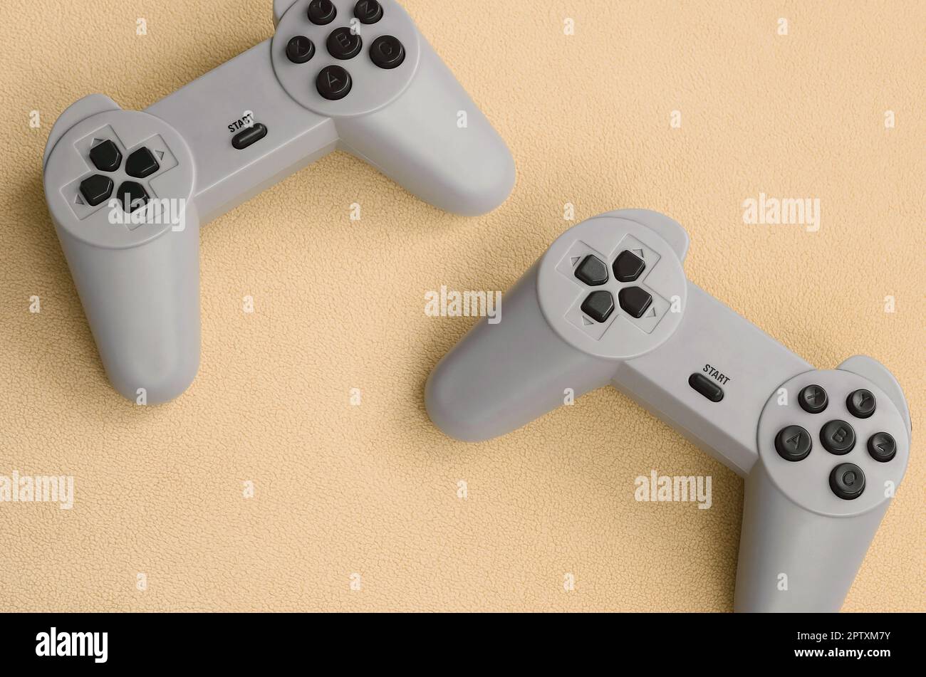 Playing games concept. Two pad joysticks lies on the blanket of furry ...