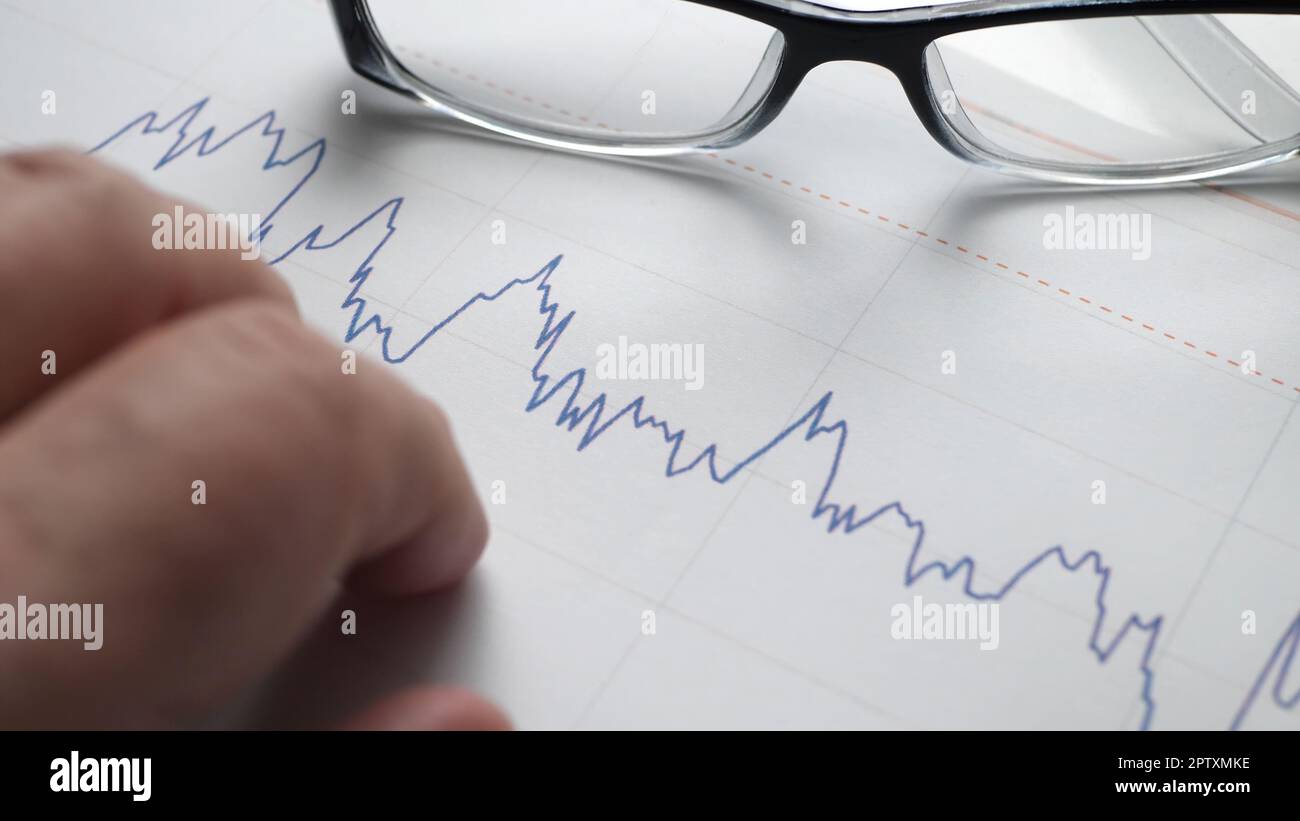 Finger tapping on stock chart Stock Photo - Alamy