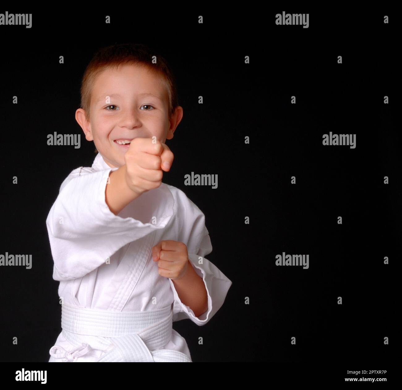 Young boy in karate outfit making fighting movement Stock Photo - Alamy