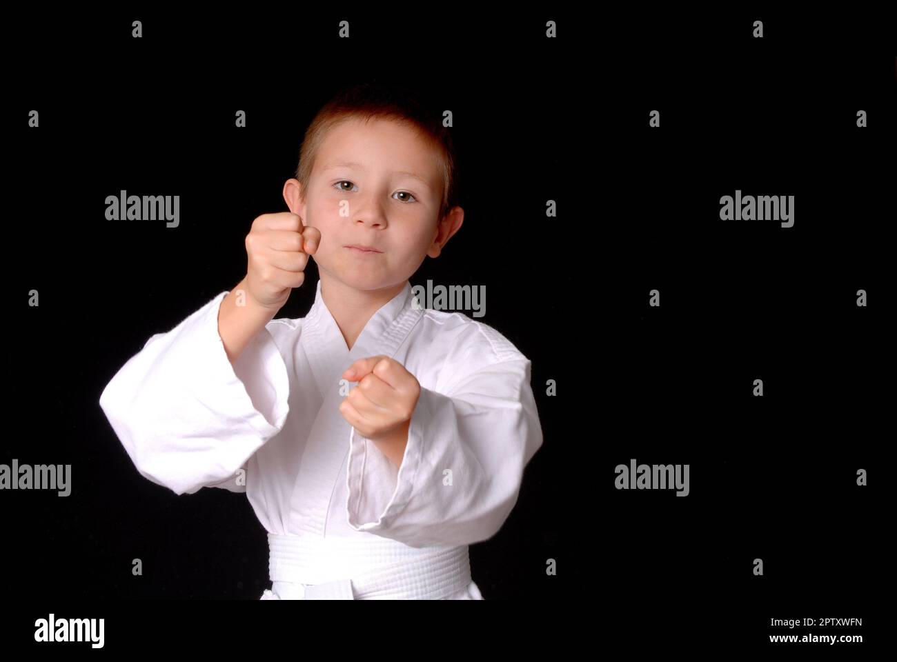 Young boy in karate outfit making fighting movement Stock Photo - Alamy