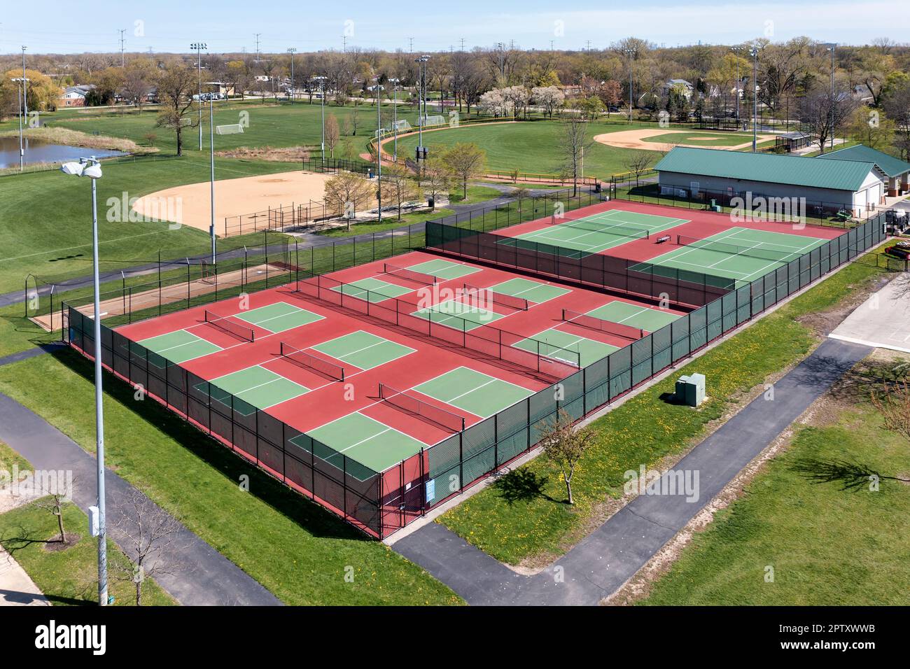 Aerial view of a pickleball facility with red and green courts in a ...
