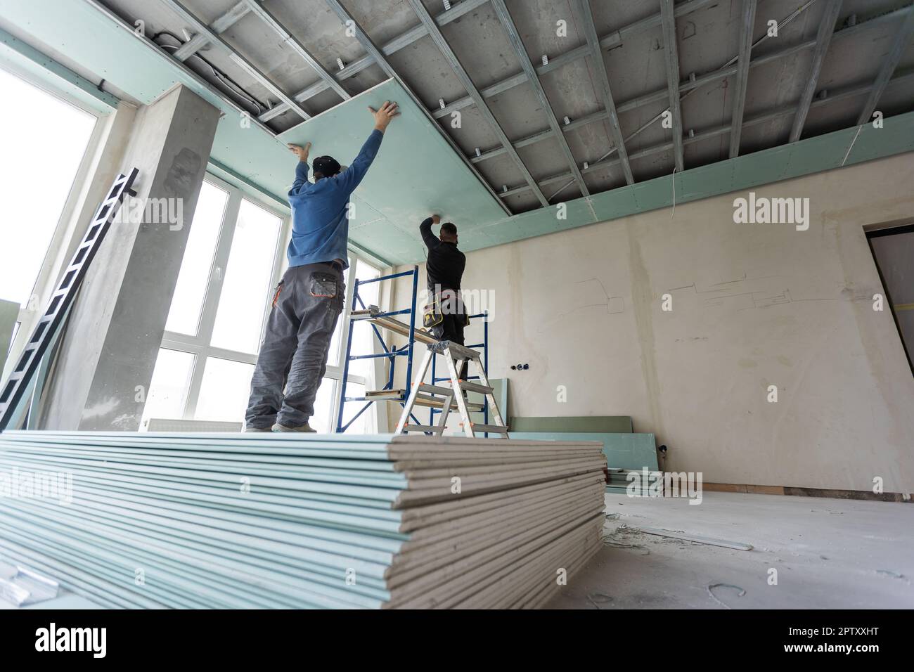 Construction worker installation ceiling work Stock Photo - Alamy