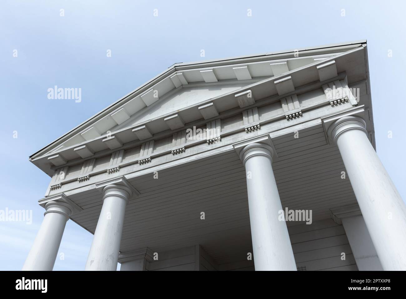 White columns and portico under blue sky, classic architecture template. Wooden temple exterior ...