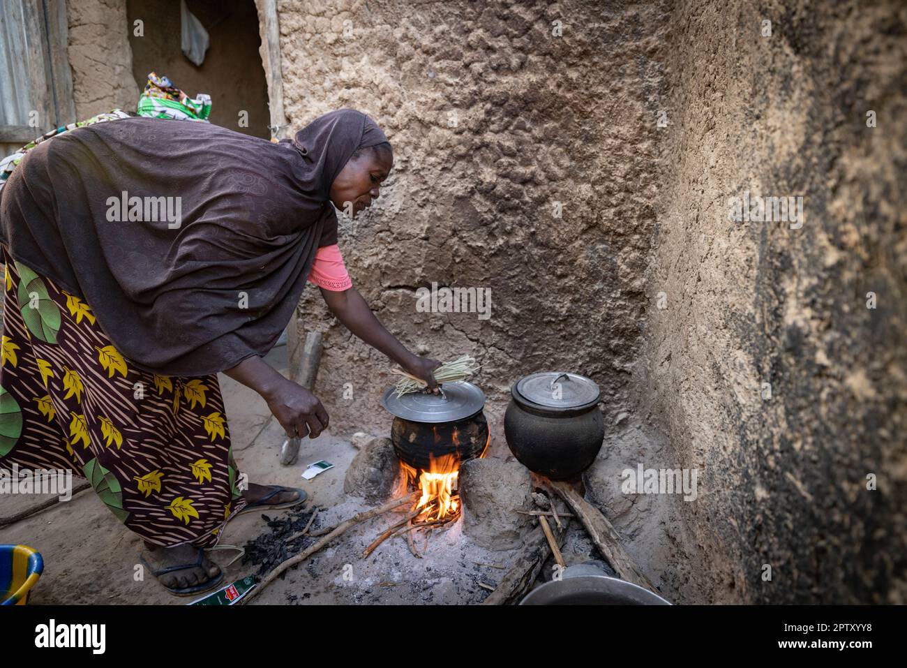 A woman cooks over an open fire at her home in Segou Region, Mali, West ...