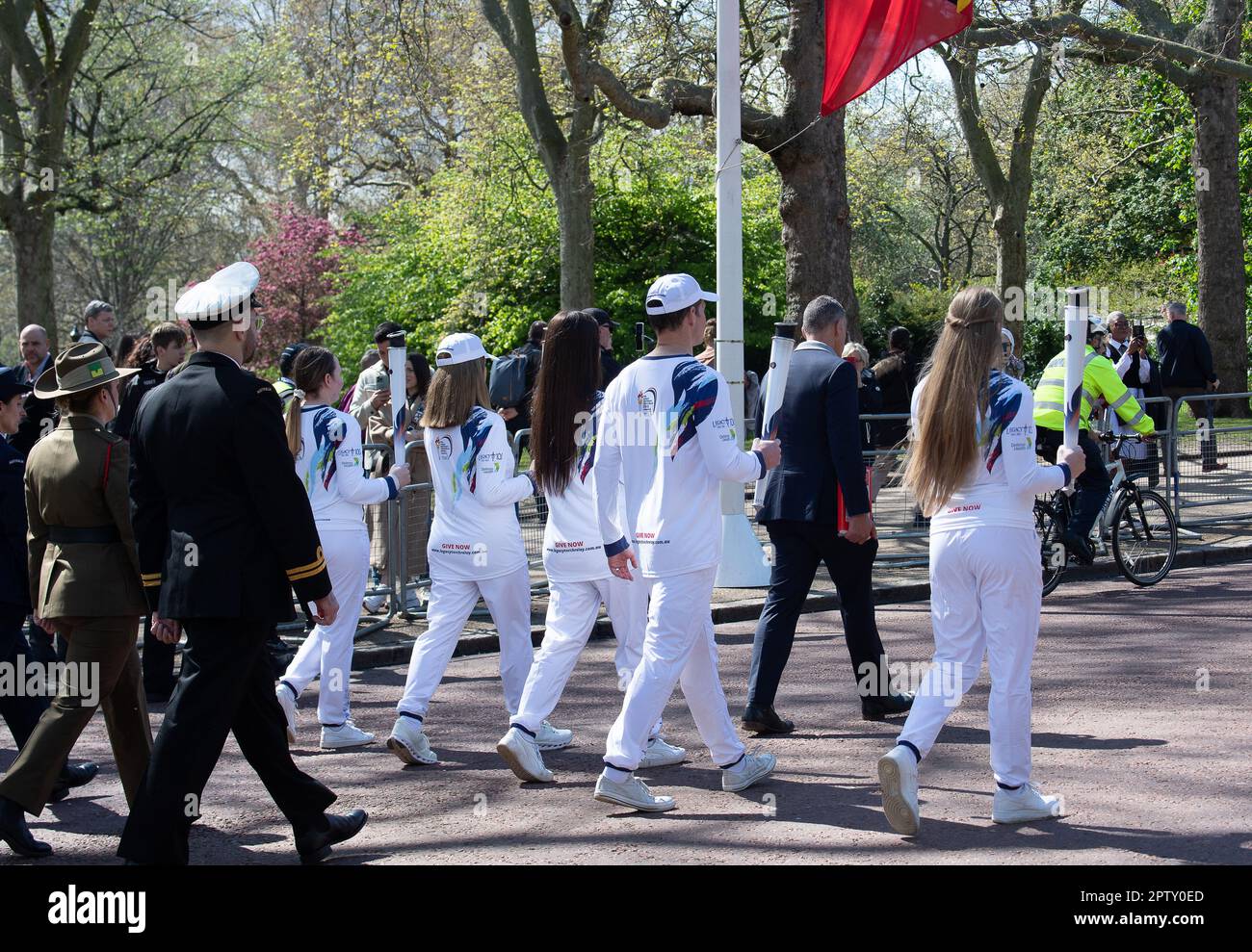 London, UK. 28th April, 2023. Torch bearers accompanies by military ...