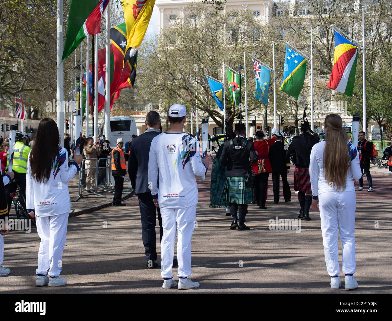 London, UK. 28th April, 2023. Torch bearers accompanies by military ...