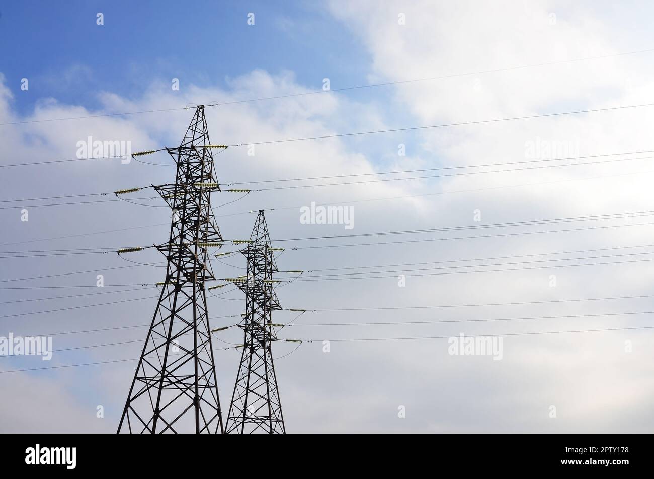 The silhouette of the electricity transmission pylon in daytime ...