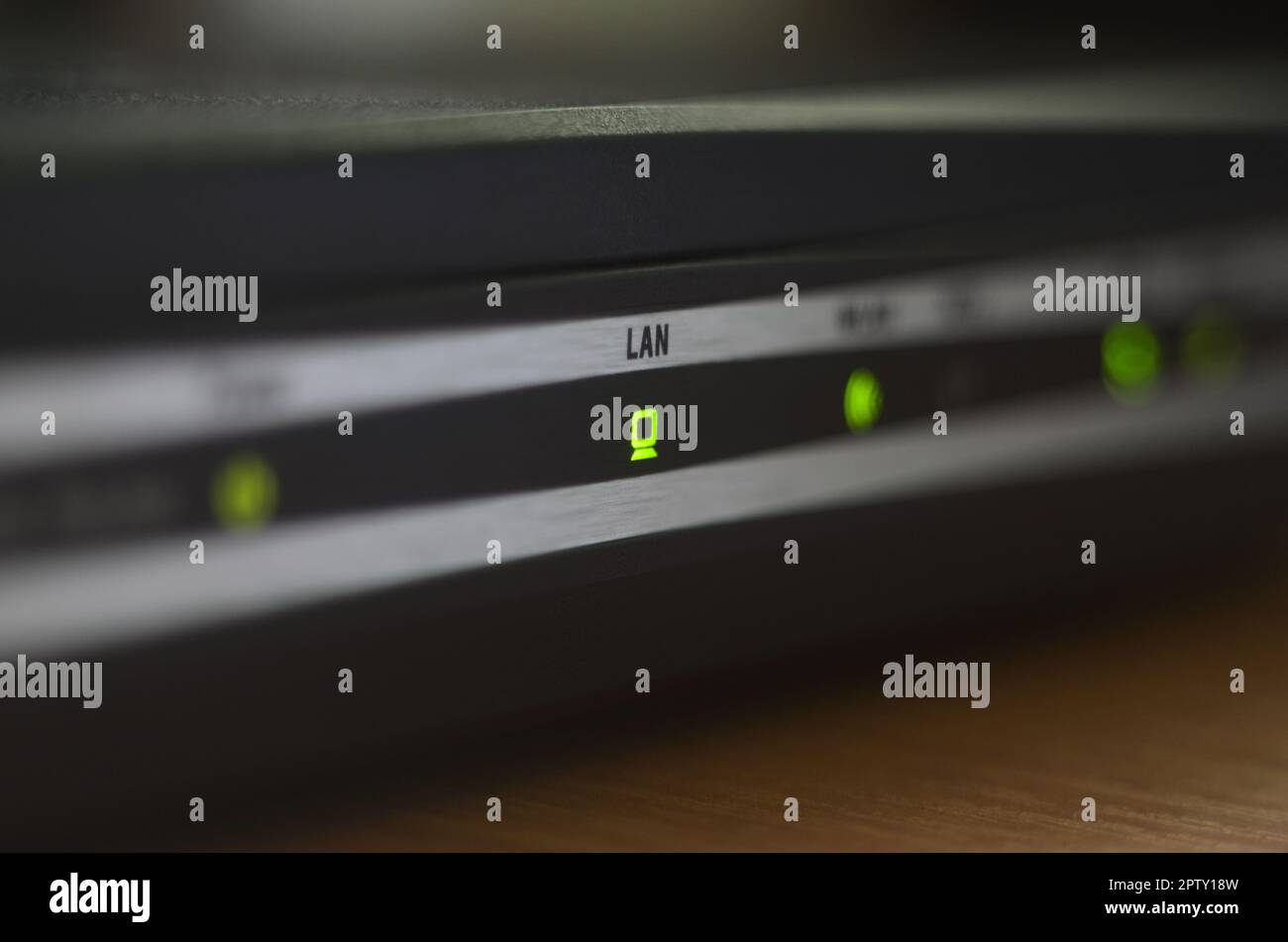 Macro of internet modem, abstract technology background. Green "LAN ...