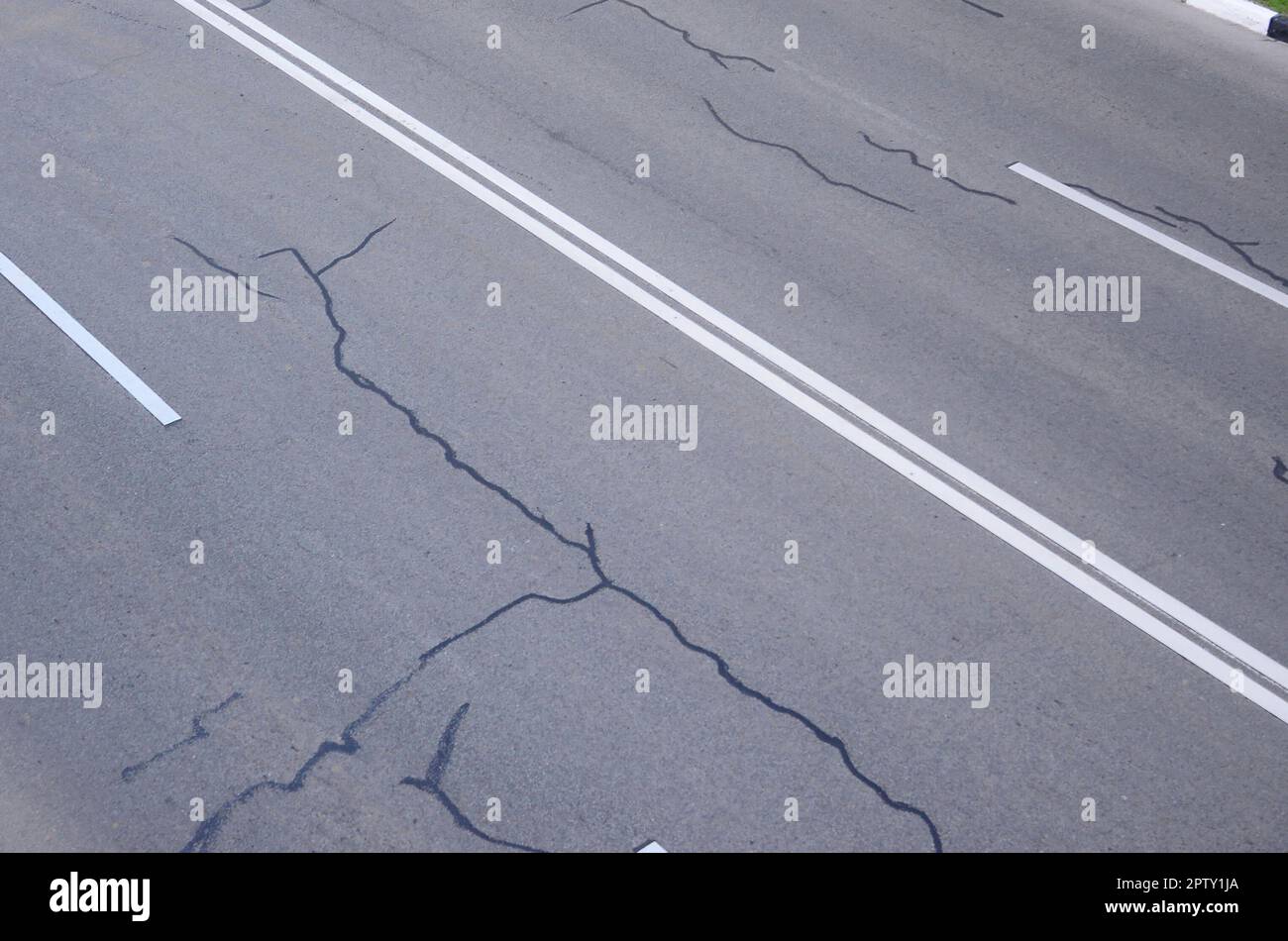 Damaged bad asphalt road with potholes. Patch repair of asphalt. Bad ...