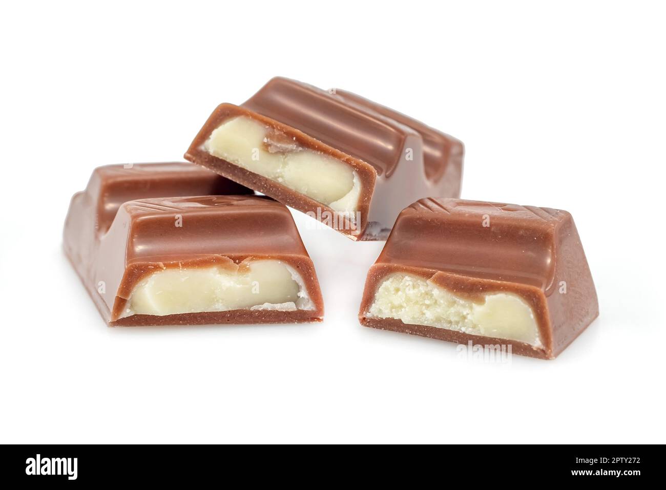 Pieces of chocolate with soft milk filling on a white background ...